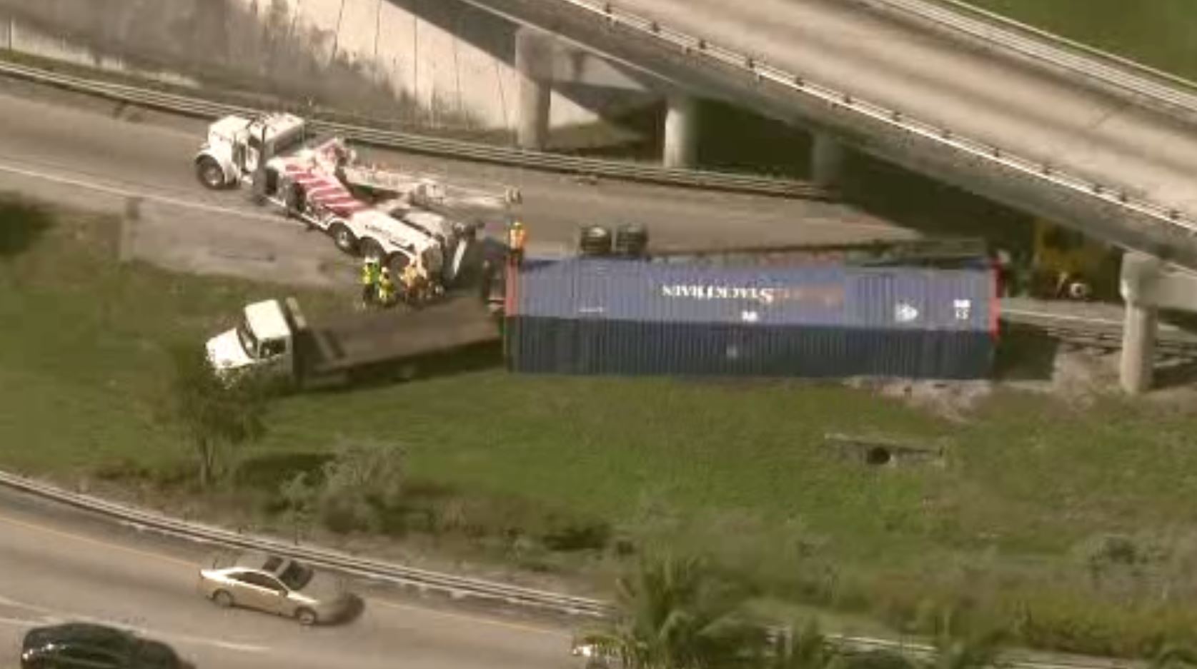 Crews work to clear roadway after container falls off tractor-trailer ...