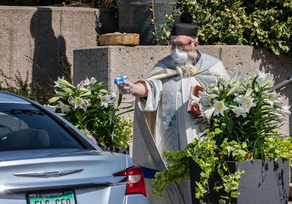 A priest fired holy water through a squirt gun at his congregants ...