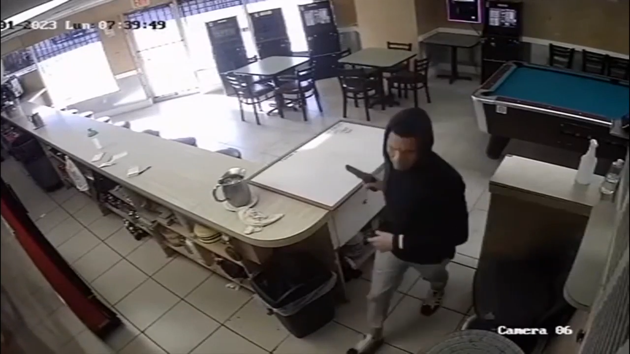 Surveillance Footage Captures Alleged Armed Robber Stealing Cash