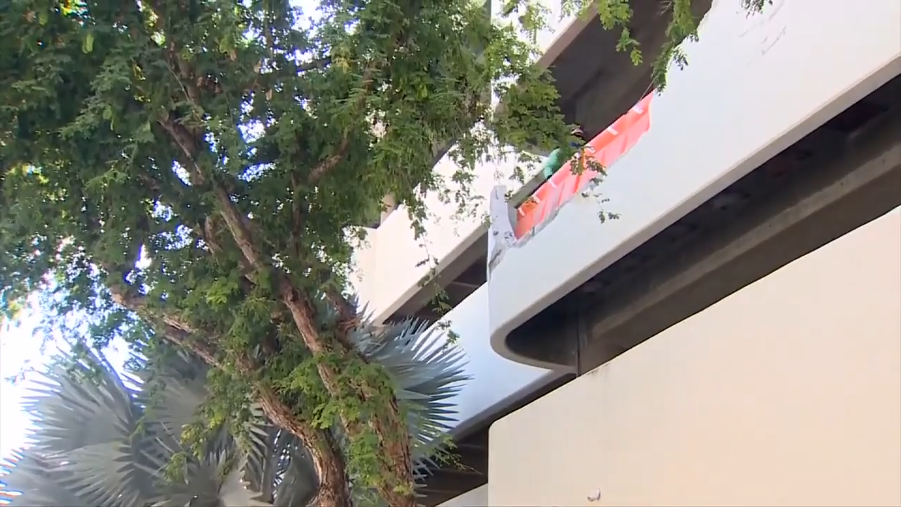 Construction crews work to fix parking garage wall after car crashes ...